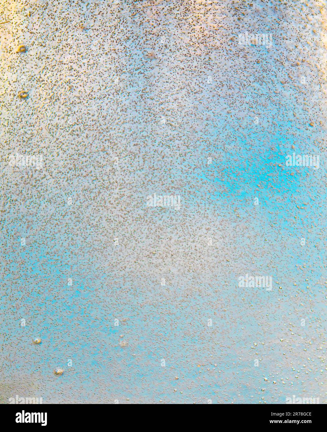 Boiling and sparkling water in a glass pot, colorfull bubbles and ...