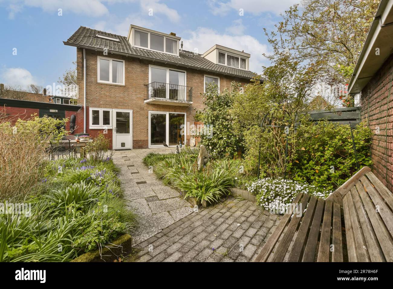 a house in the netherlands with plants and flowers on the front yard ...
