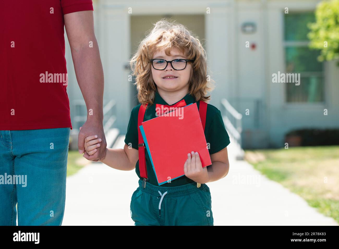 Teachers day. Portrait of happy nerd pupil holding teachers hand ...