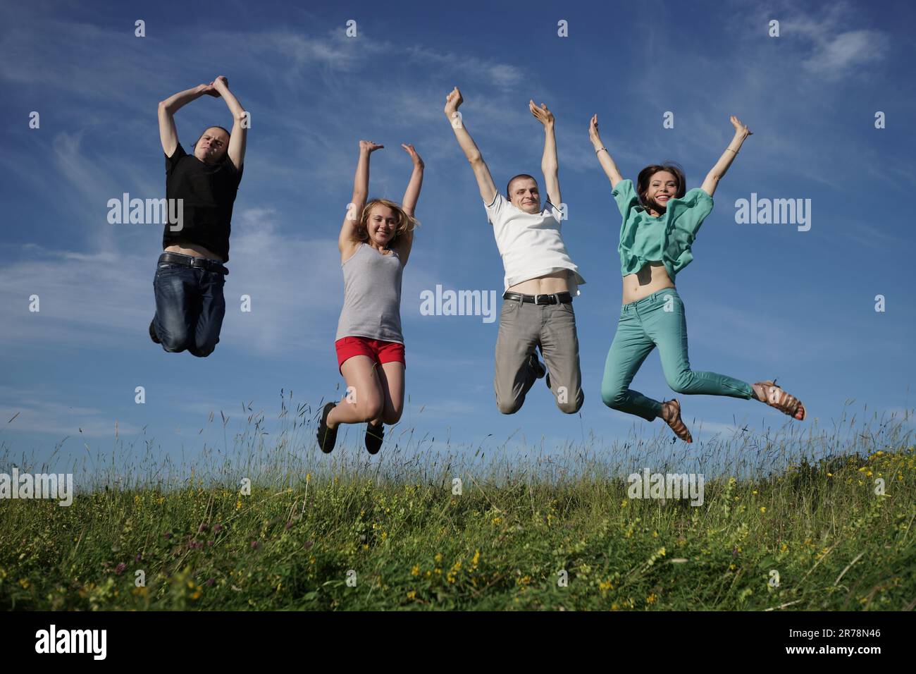Happy group of jumping people on grean meadow Stock Photo - Alamy