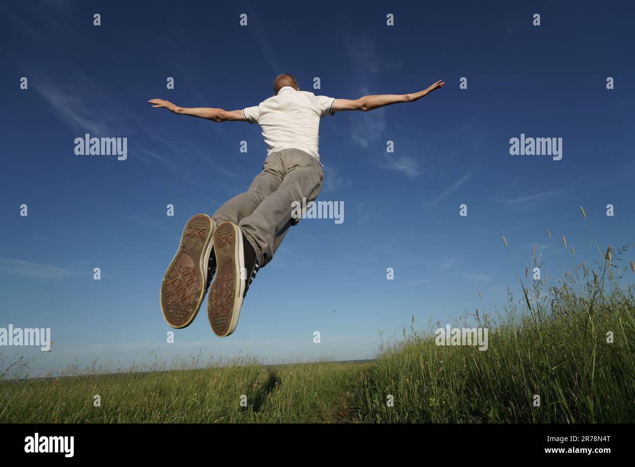 Man jumping on the grass field Stock Photo - Alamy