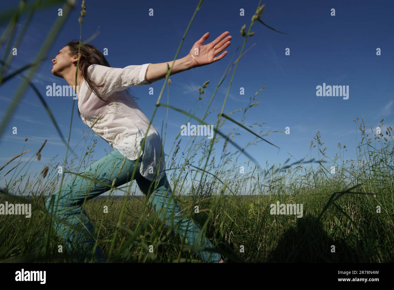 Woman run through grass field Stock Photo - Alamy
