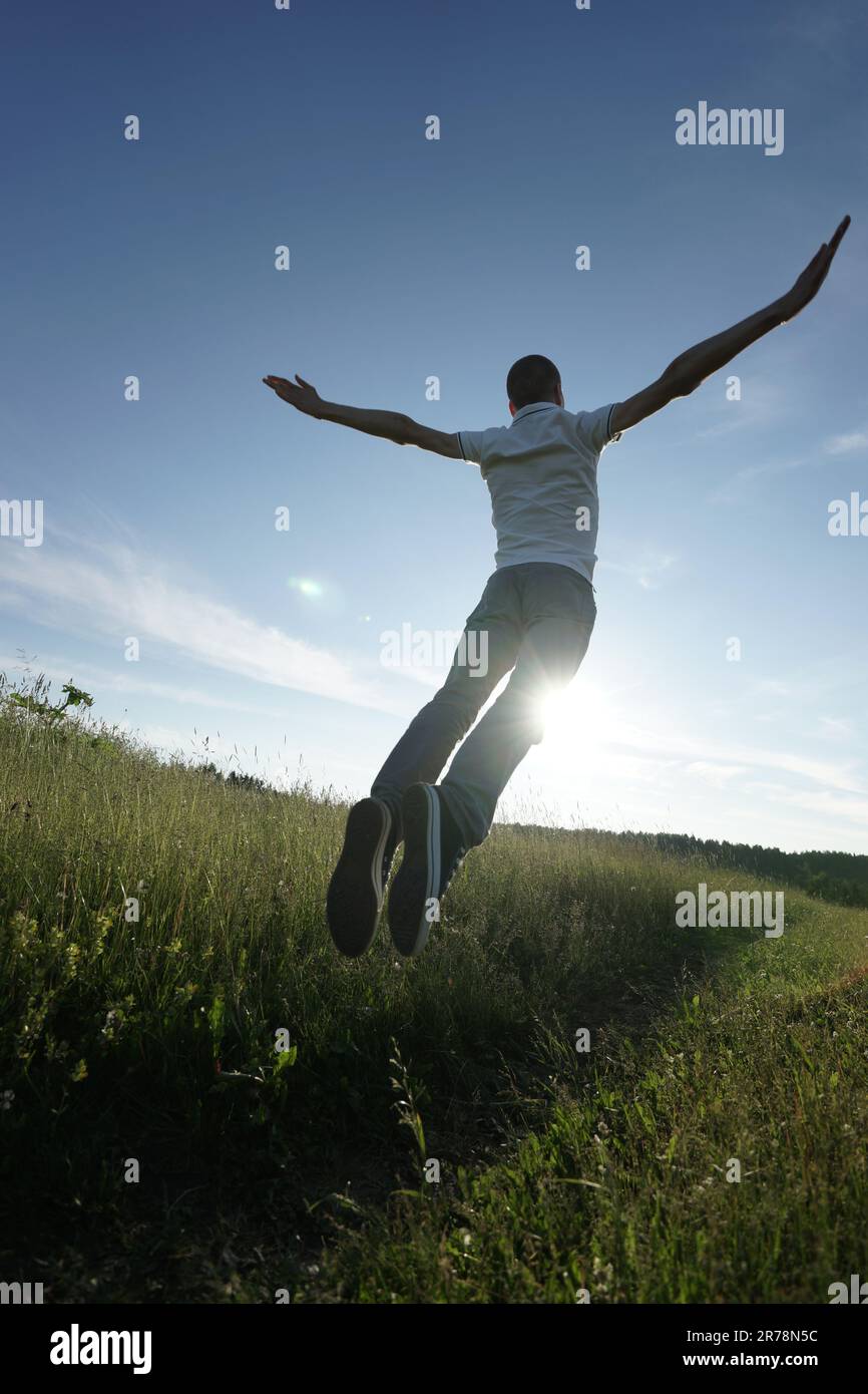 Man jumping on the grass field Stock Photo - Alamy
