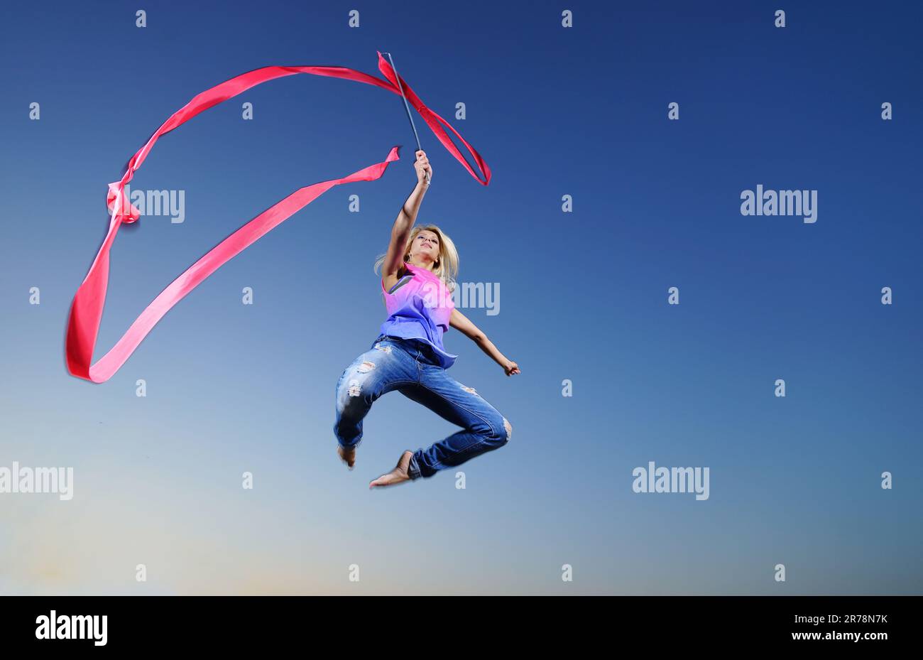 Professional gymnast woman dancer jumping with ribbon Stock Photo - Alamy