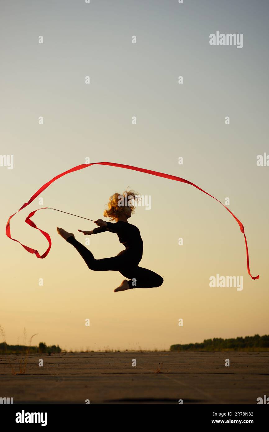 Professional gymnast woman dancer jumping with ribbon Stock Photo - Alamy