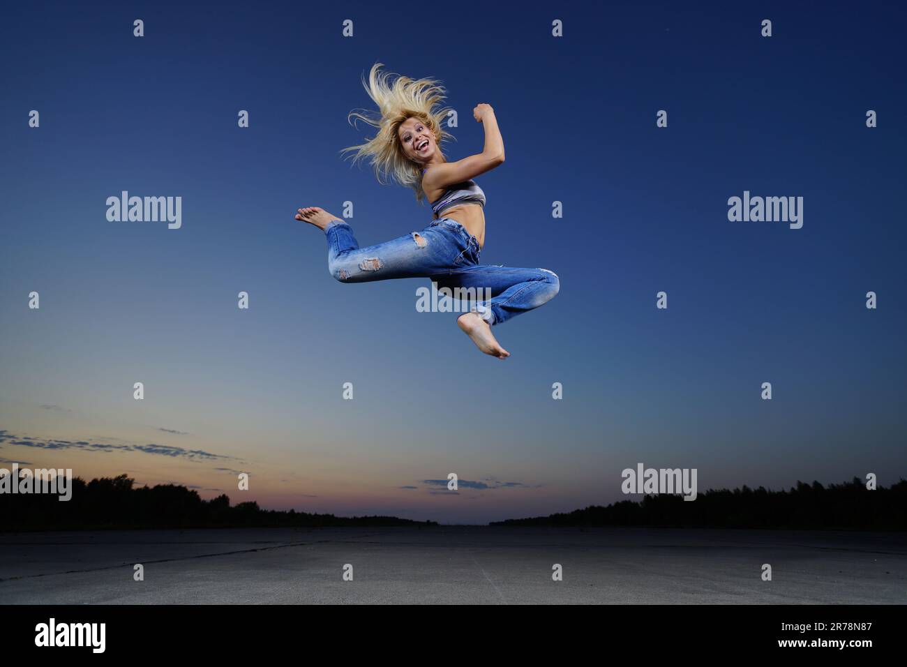 Professional gymnast woman jump at night Stock Photo - Alamy