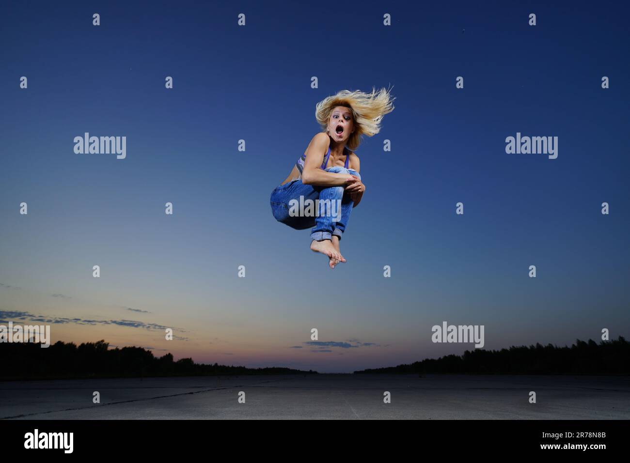 Professional gymnast woman jump at night Stock Photo - Alamy