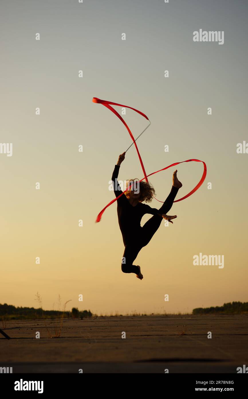 Professional gymnast woman dancer jumping with ribbon Stock Photo - Alamy