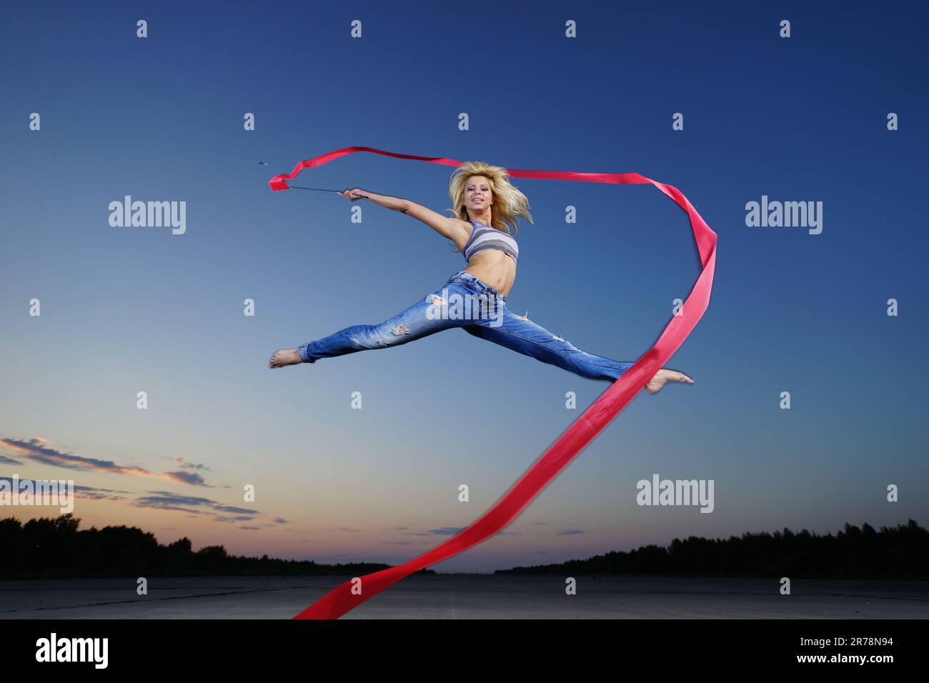 Professional gymnast woman dancer jumping with ribbon Stock Photo - Alamy