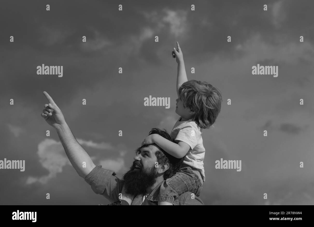 Fathers day. Cute boy with dad playing outdoor. Happy child pointing on ...