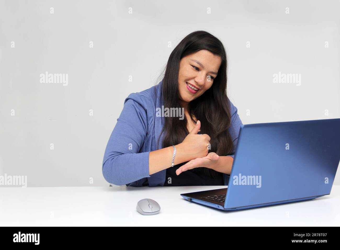 Latino Adult Woman Speaks Mexican Sign Language With A Deaf Person Through A Laptop In A Video
