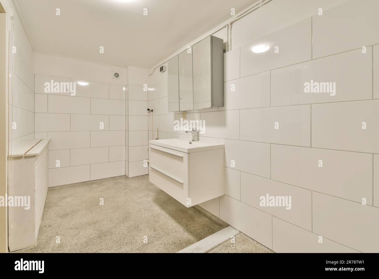 an empty bathroom with white tiles on the walls and floor, there is a ...