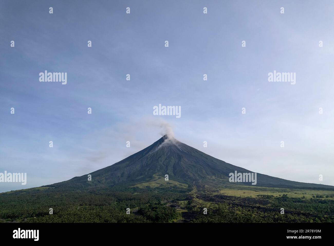 Mayon volcano belches hot emissions down its slope as seen from Daraga ...