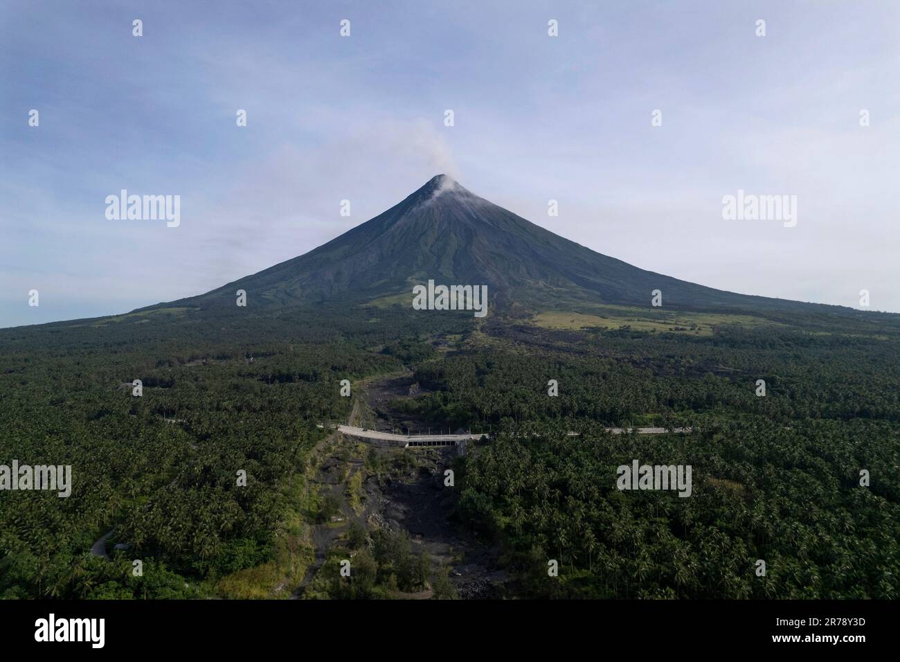Mayon volcano belches hot emissions down its slope as seen from Daraga ...