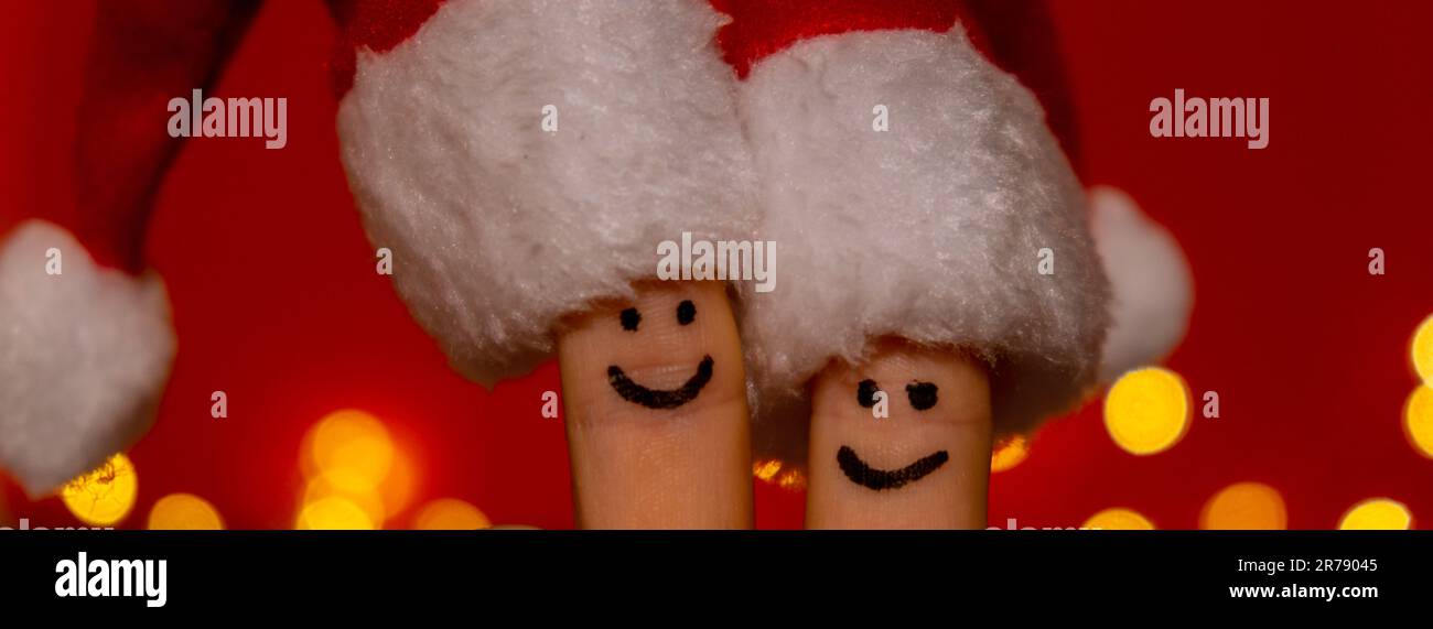Fingers dressed in Santa-Claus red-white hats. Two happy finger smileys ...