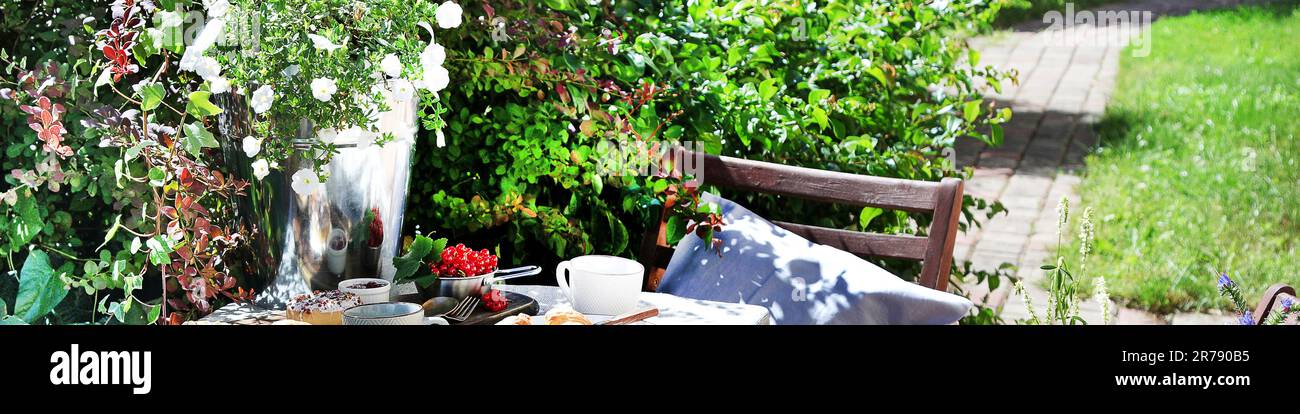 Continental breakfast on the garden table. Country lifestyle or weekend ...