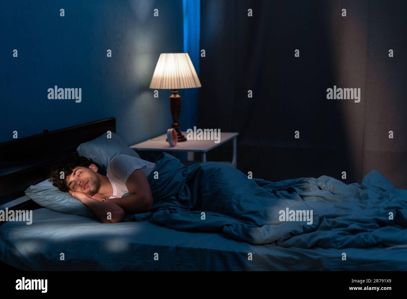Young arabic man sleeping in bed at home at night. People, bedtime and ...