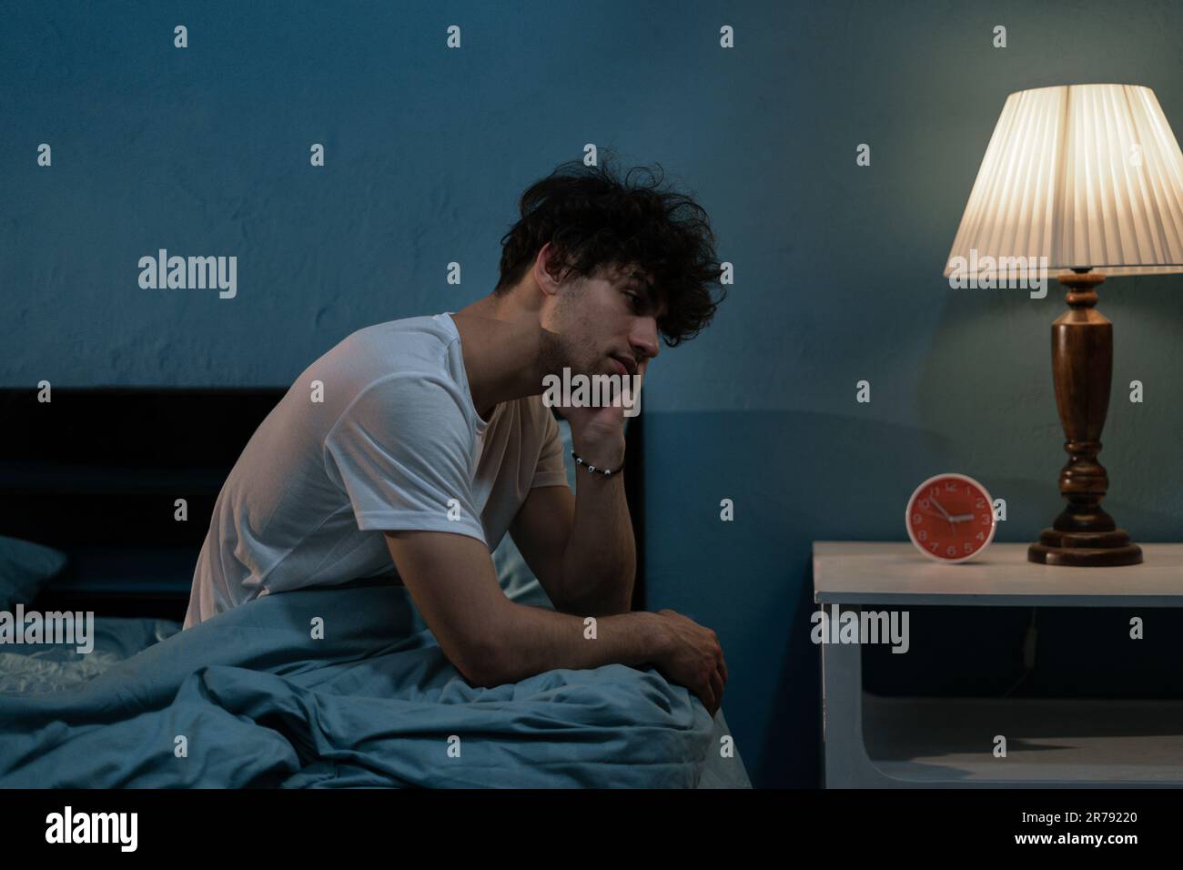 Depressed young arabic man sitting in bed cannot sleep from insomnia ...