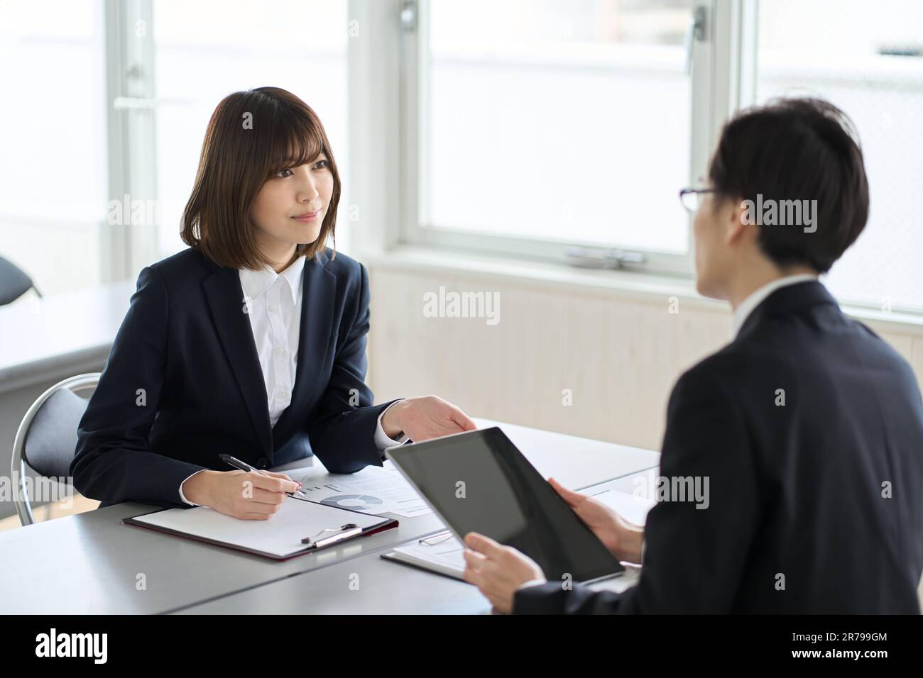Asian business person showing and explaining a tablet Stock Photo - Alamy