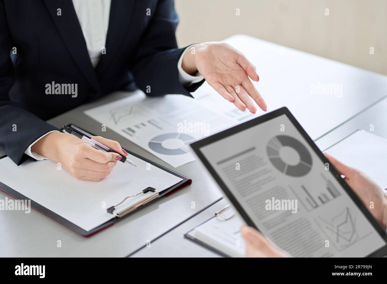 Asian business woman showing and explaining a tablet Stock Photo - Alamy