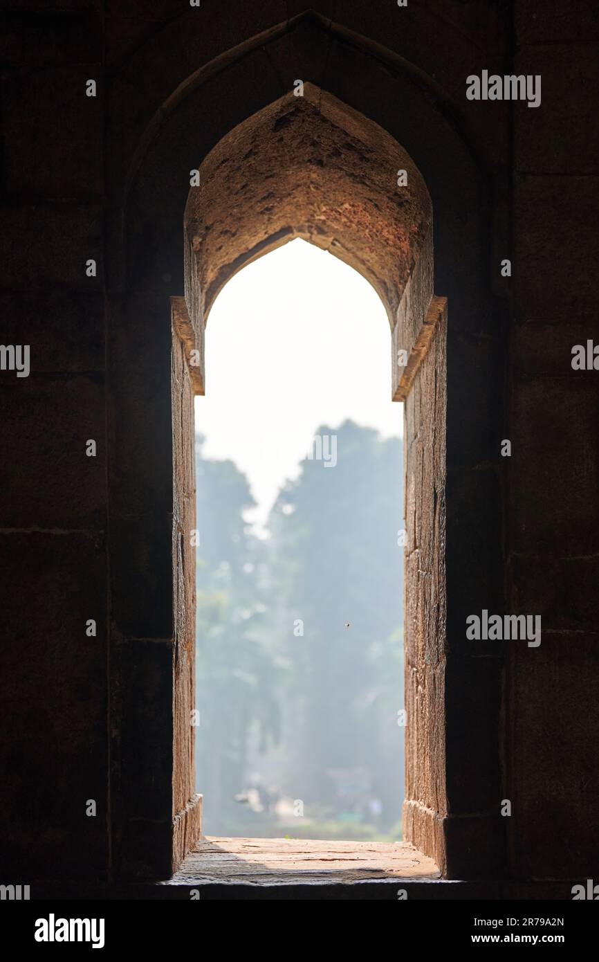 Window opening of ancient indian tomb with green park view, old stone ...