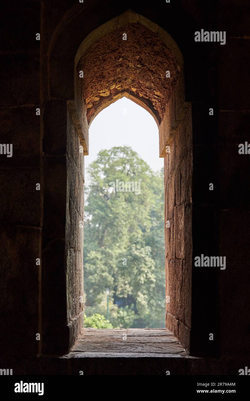 Window opening of ancient indian tomb with green park view, old stone ...