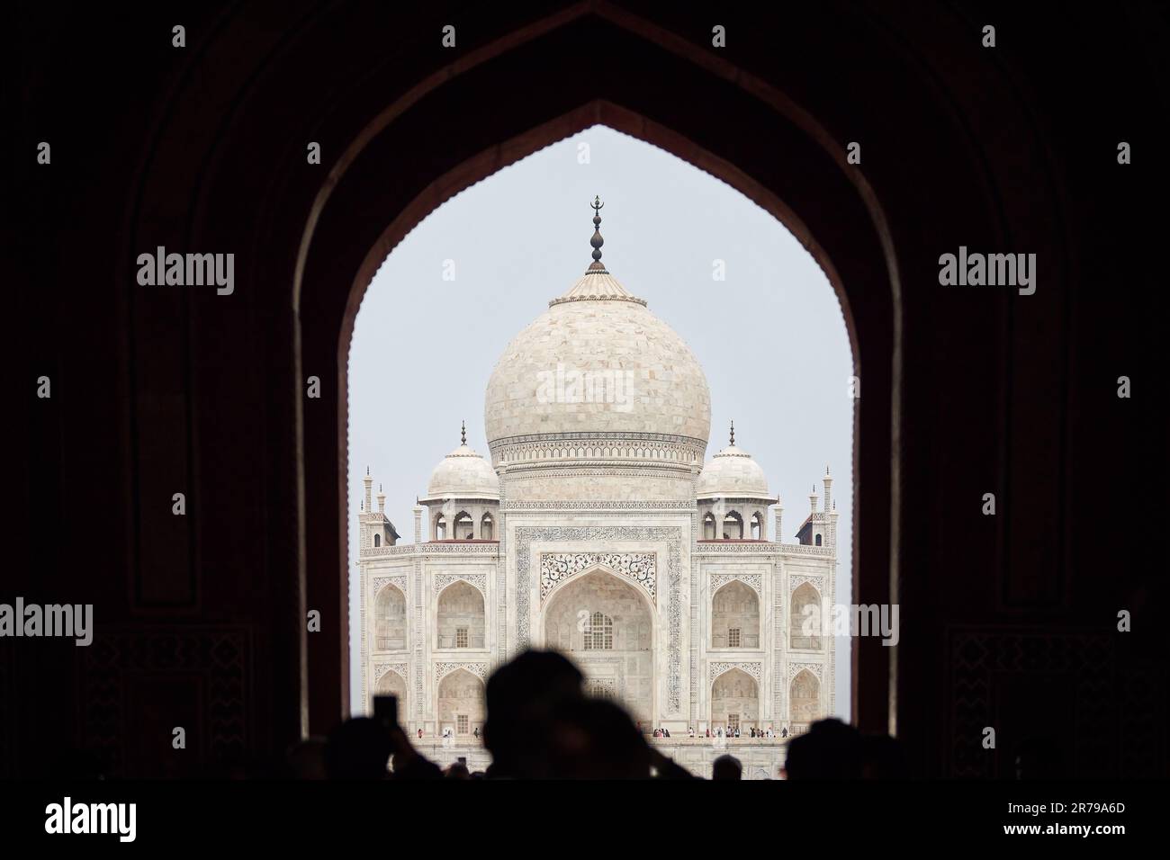 Archway of main gateway in Taj Mahal entrance with tourists silhouettes ...