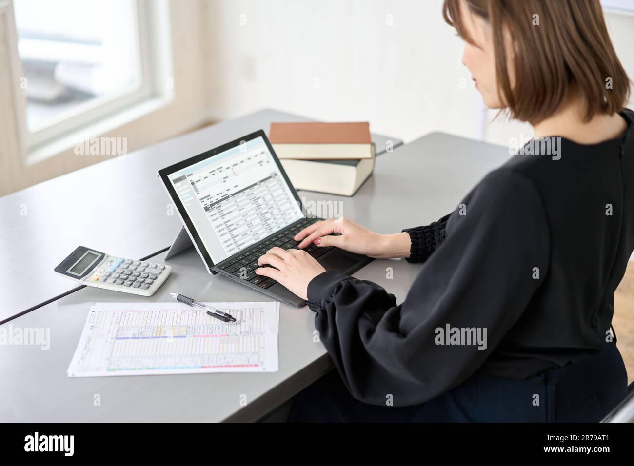 Asian woman entering journal entries in accounting software Stock Photo ...