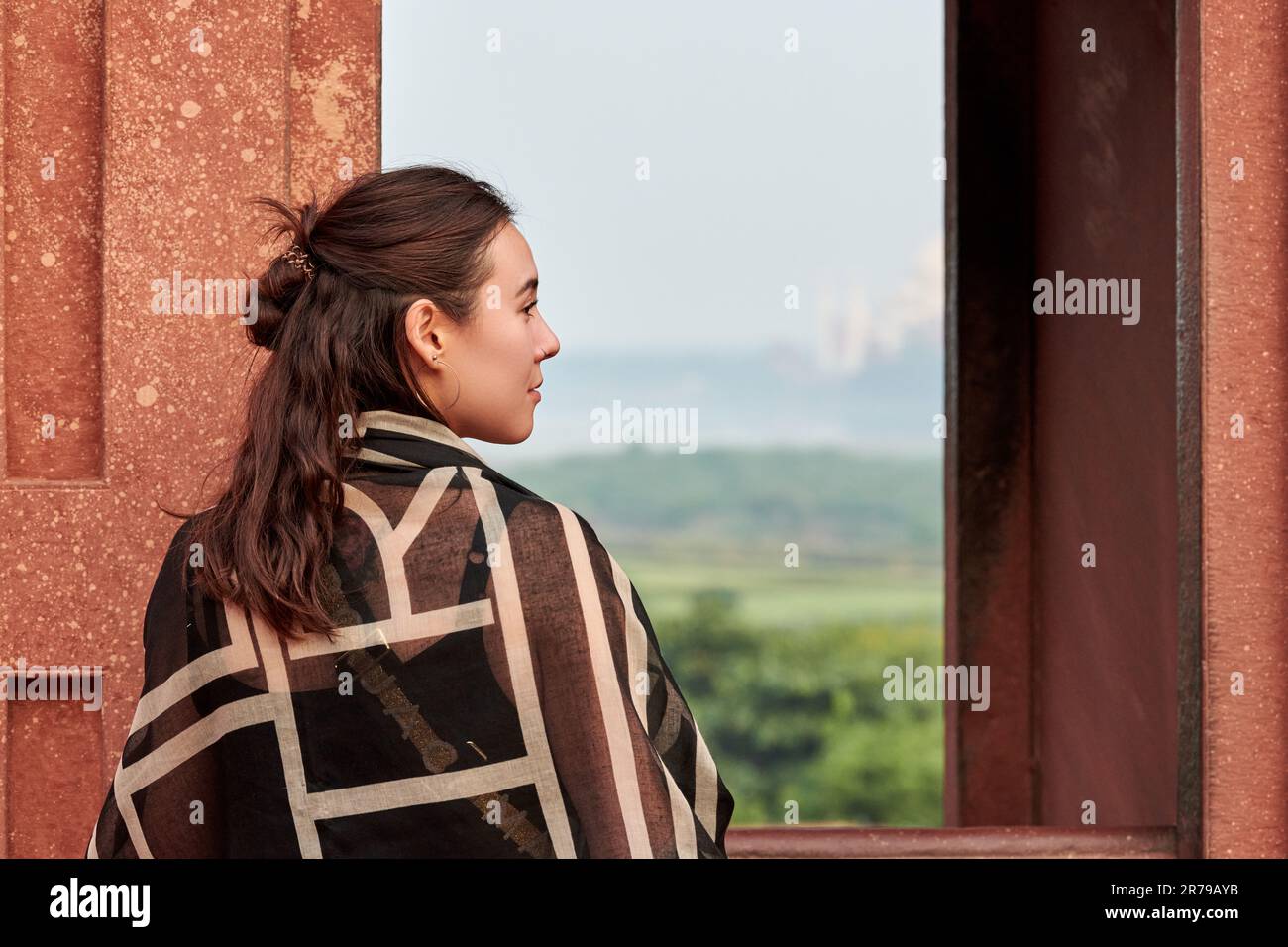 Rear view east asian woman in black dress look at Taj Mahal through ...