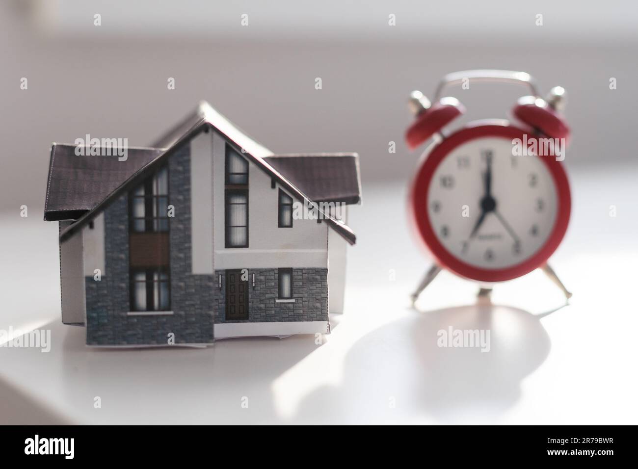Toy House and alarm clock isolated on white Stock Photo - Alamy