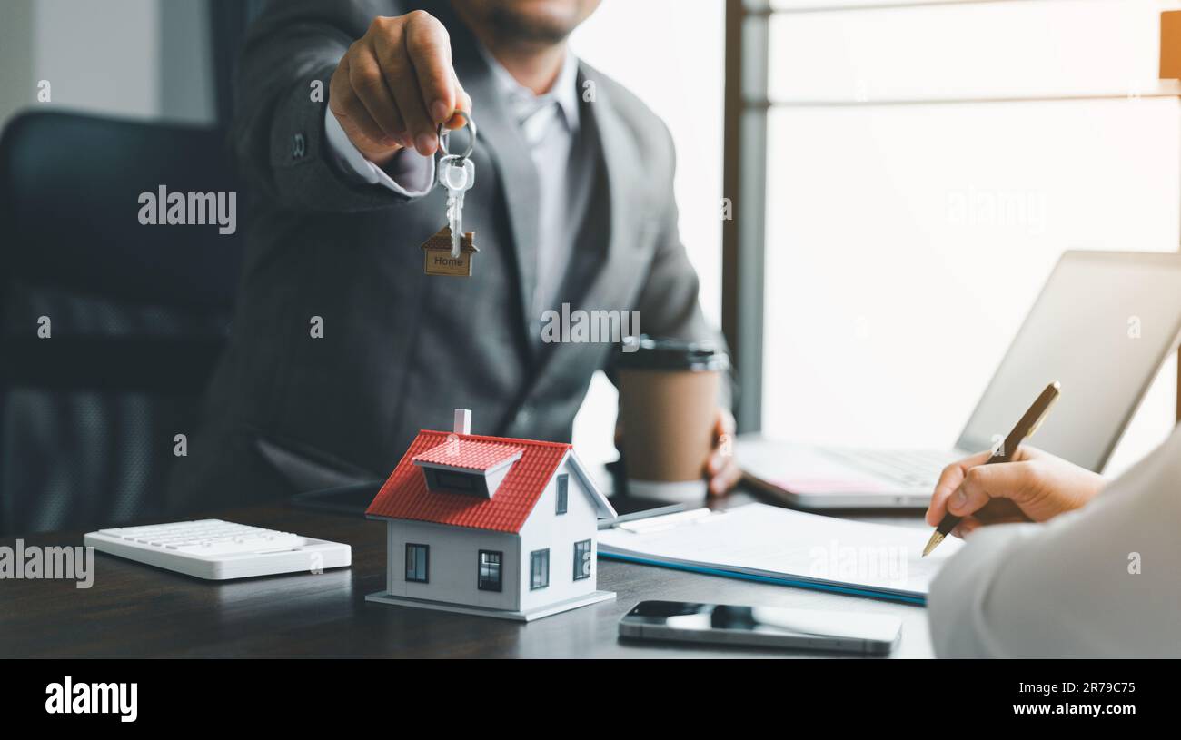 Home sales and home insurance concept. Estate agent giving house keys ...
