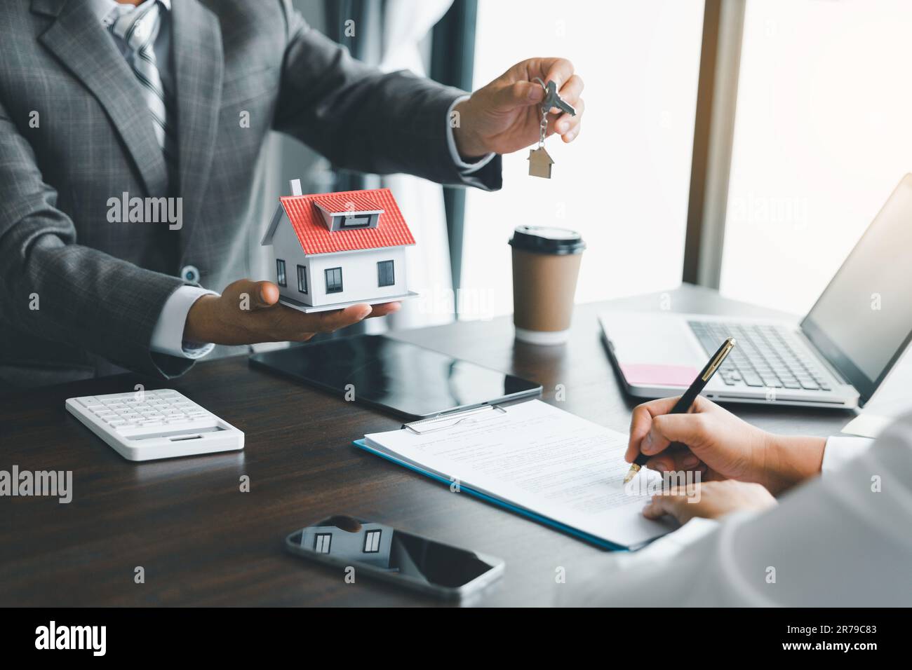 Home sales and home insurance concept. Estate agent giving house keys ...