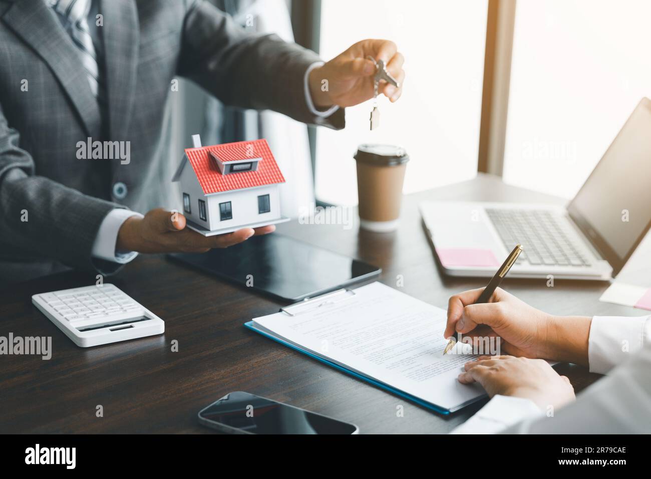 Home sales and home insurance concept. Estate agent giving house keys ...