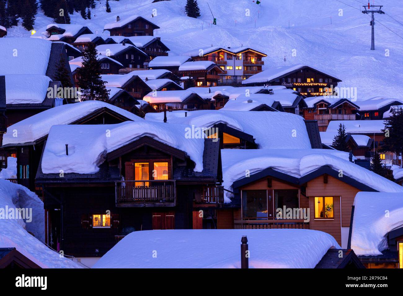 Wooden chalets covered with deep snow in cold winter season at the blue ...