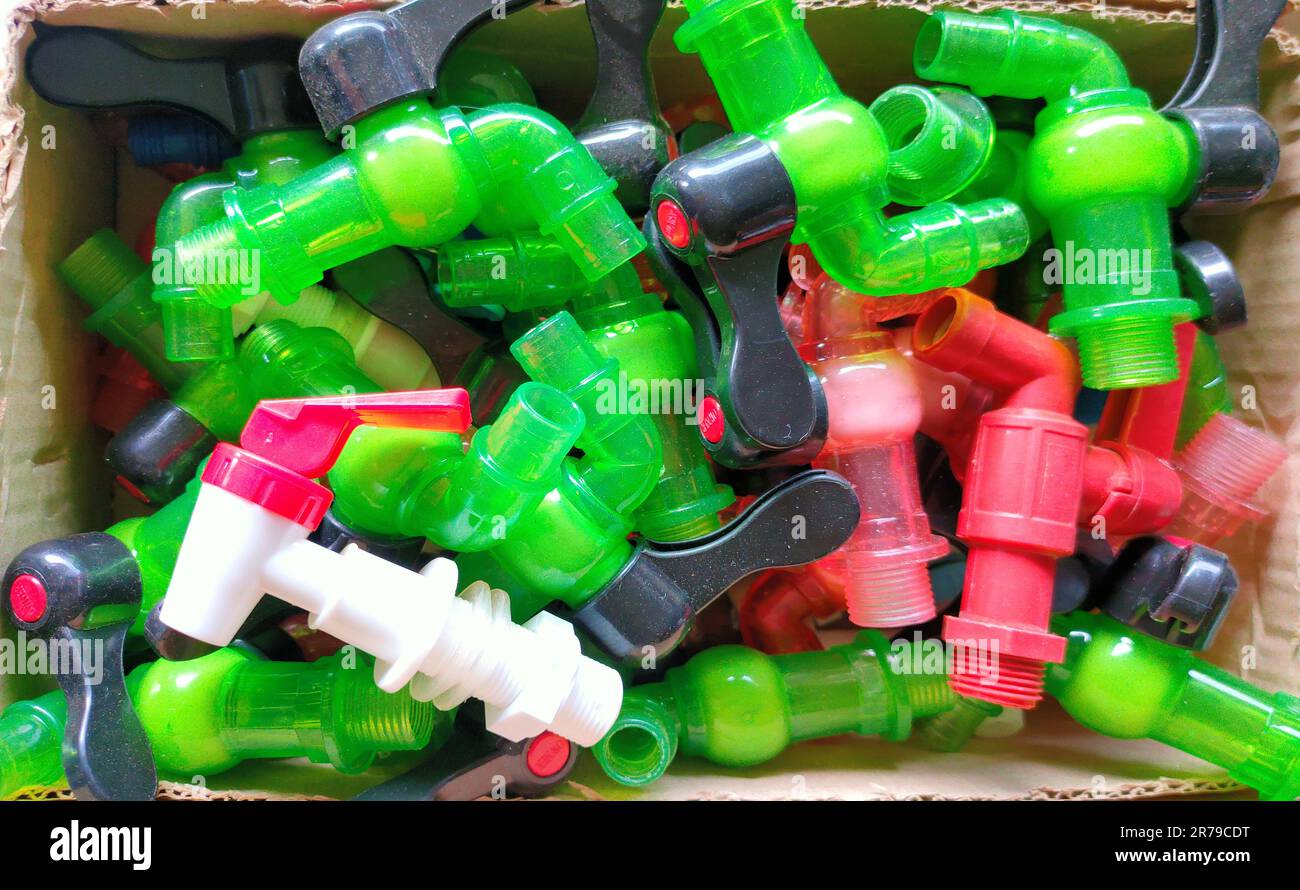 Pile of colorful plastic faucets in boxes, on the market at a hardware ...