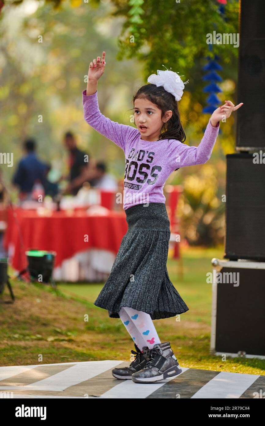 New Delhi, India - 10.12.2022 - Little girl dance to music at outdoor ...