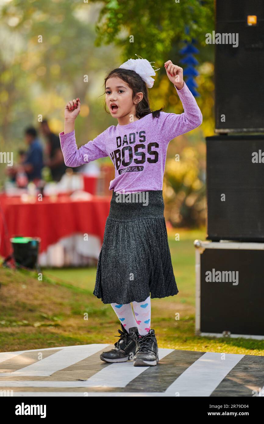 New Delhi, India - 10.12.2022 - Little girl dance to music at outdoor ...
