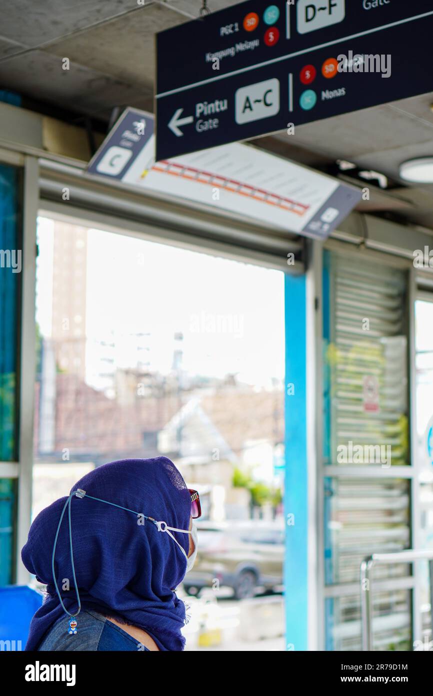 A woman looks back at a bussway direction information sign at a bussway ...