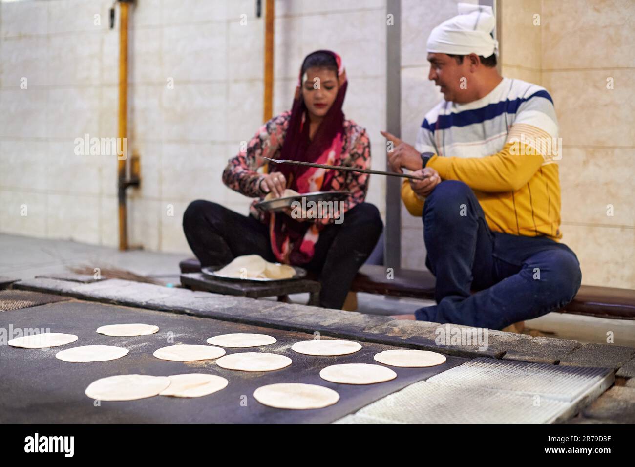 New Delhi, India - 10.11.2022 - Indian volunteers cooking chapati round ...