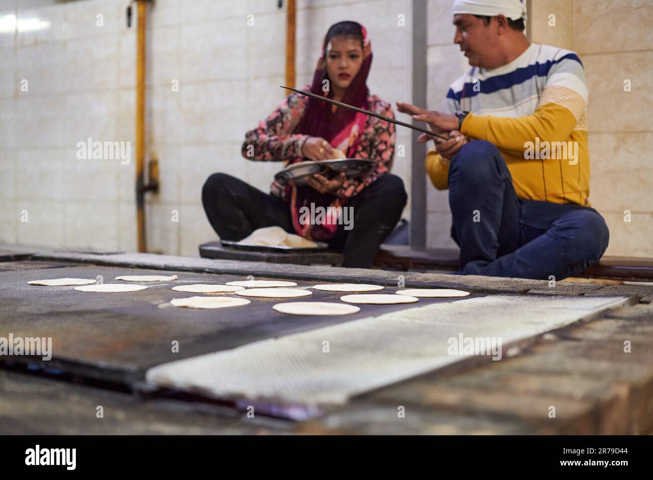 New Delhi, India - 10.11.2022 - Indian volunteers cooking chapati round ...
