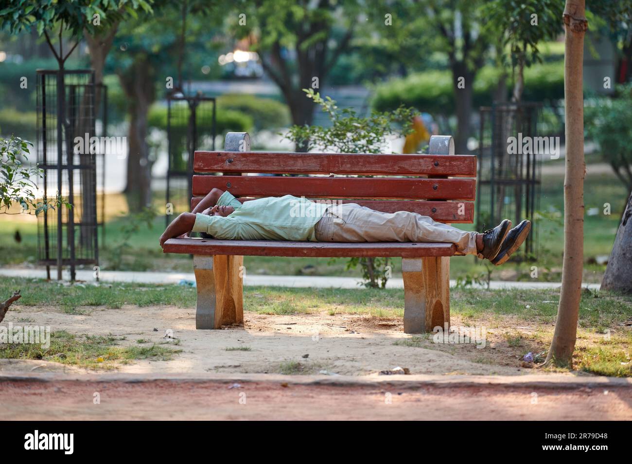 New Delhi, India - 11.11.2022 - Homeless indian man lies on bench in ...