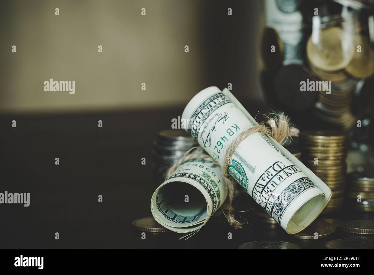Saving money by dollars with coins in jug glass on dark background ...