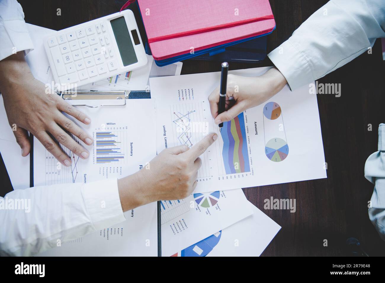 Business colleagues working and analyzing financial figures on a graphs ...