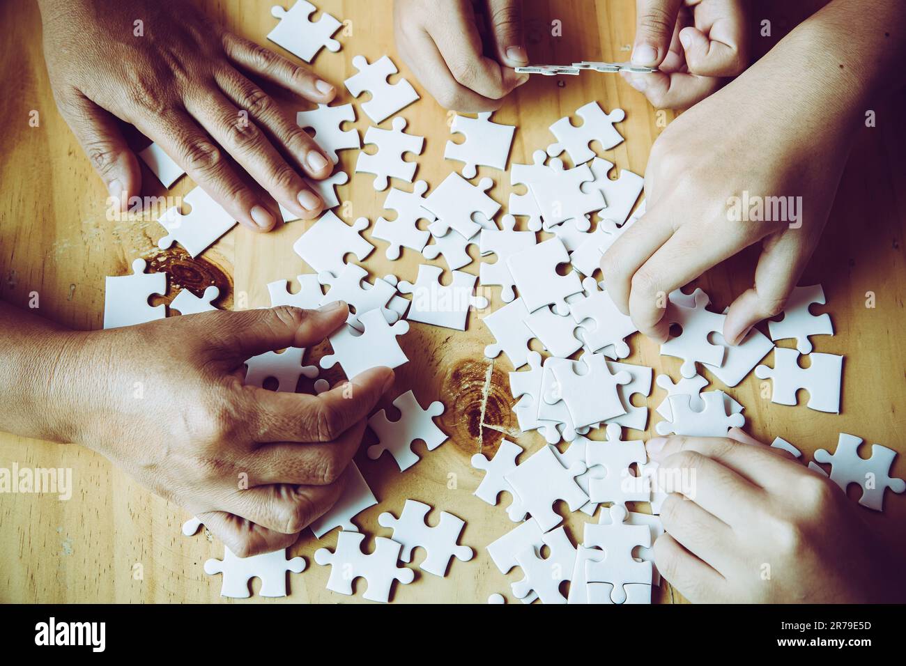 Hands of a person little child and parent playing jigsaw puzzle piece ...
