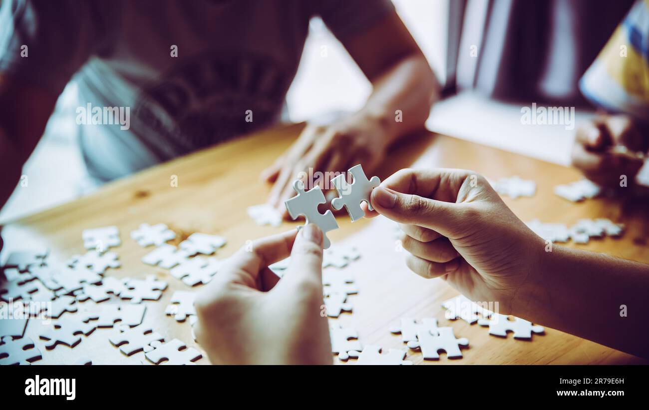 Hands of a person little child and parent playing jigsaw puzzle piece ...