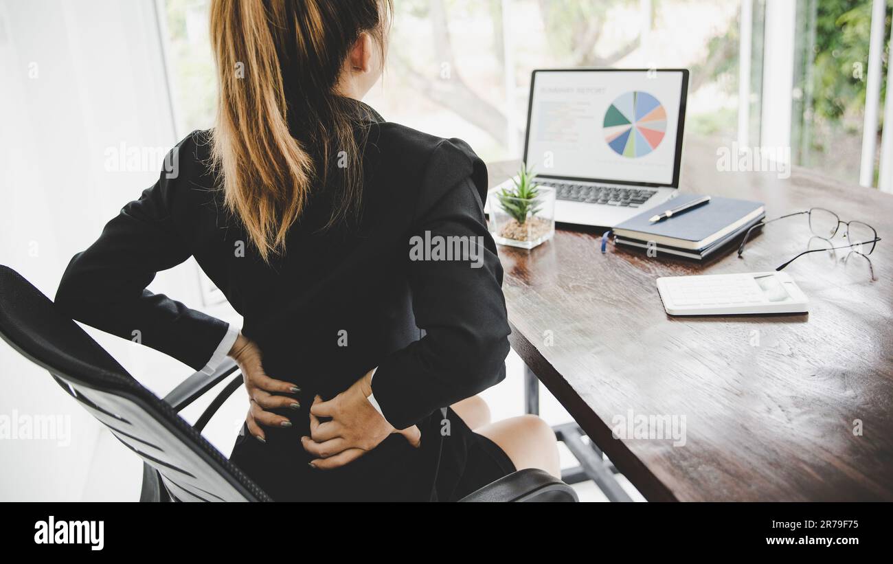 Young business woman at the office with terrible back pain while she is ...