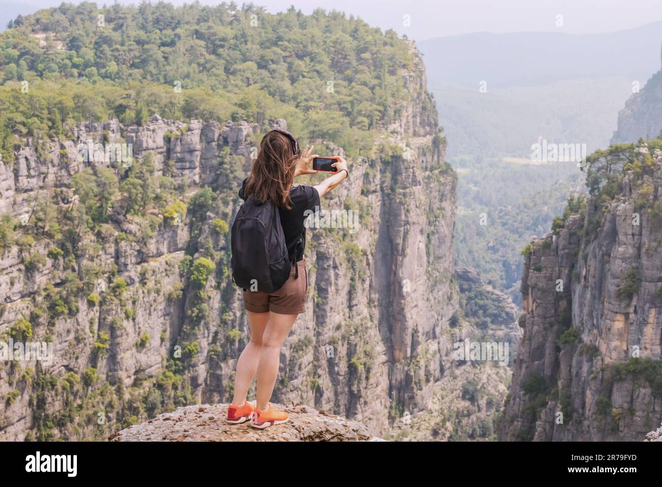 Happy traveler girl taking selfie photos standing on top of the Tazi canyon in Turkey. Tourist ...