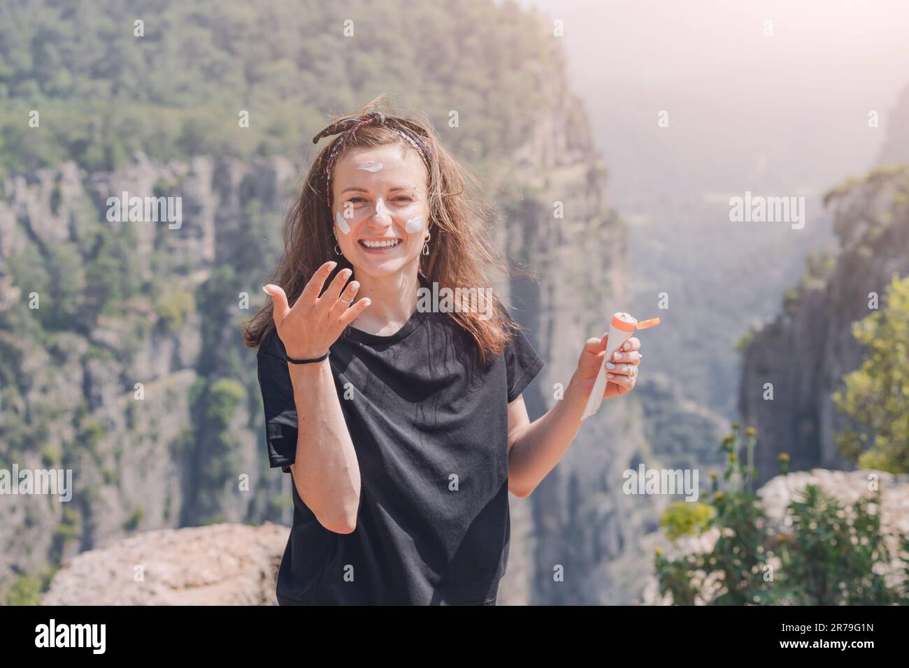 Hiker woman applying sun cream to protect her skin from dangerous uv ...