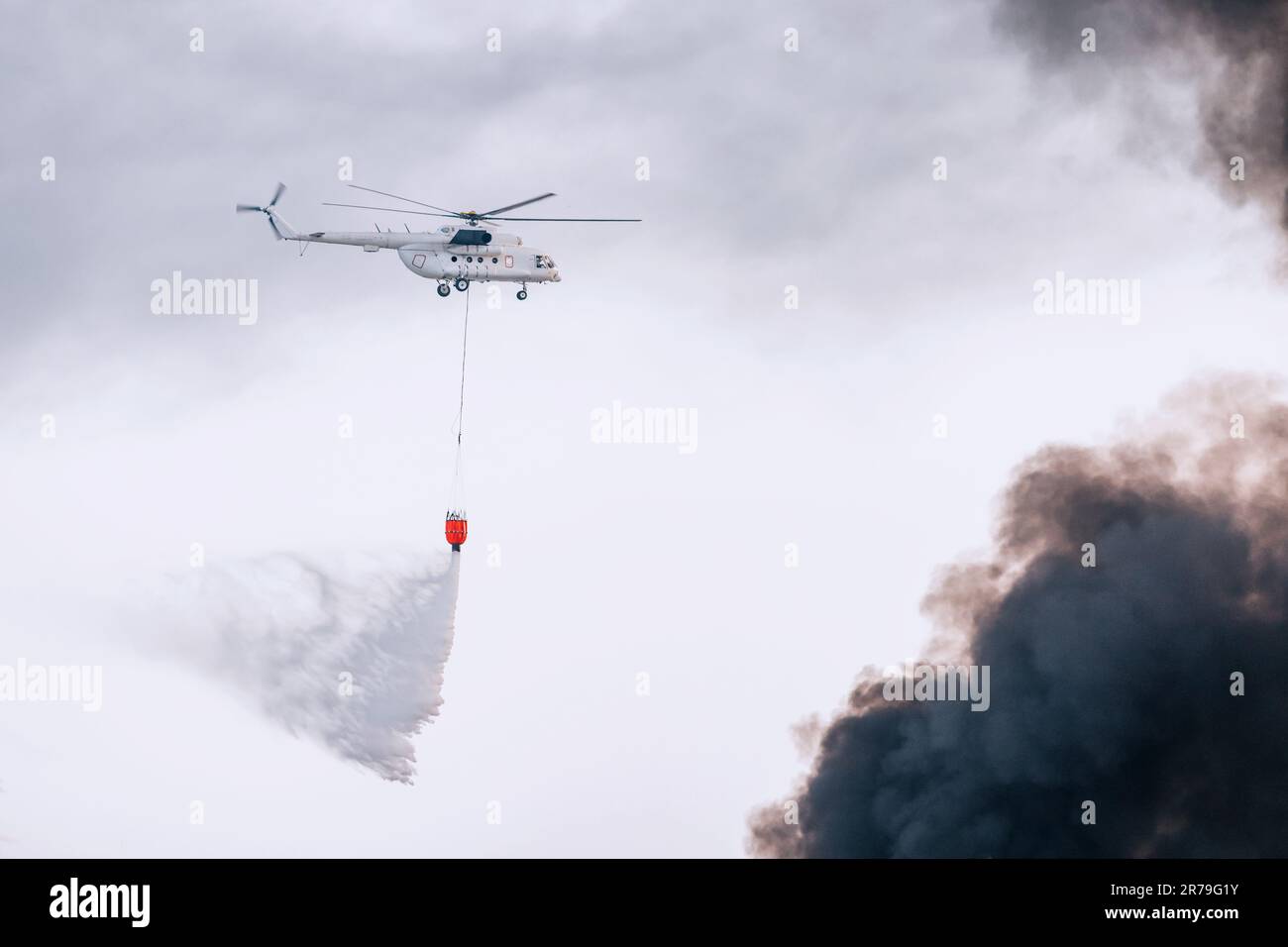 a firefighter emergency helicopter extinguishes a fire and sprays water ...