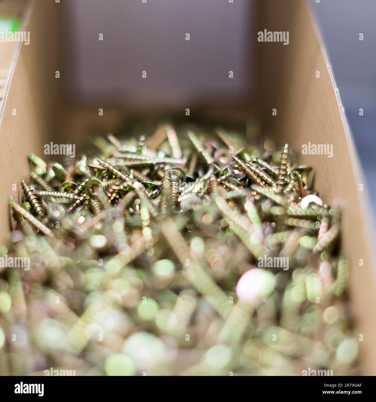 Small thin metal nails, hardware, screw lying in a store container ...